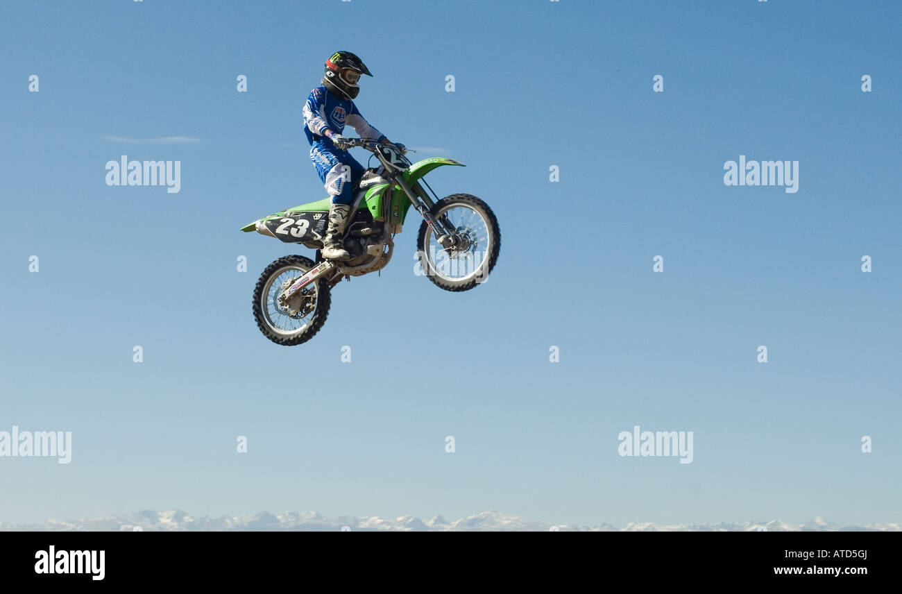 Dirt bike motorcycle rider jumping doing a trick at motocross track ...