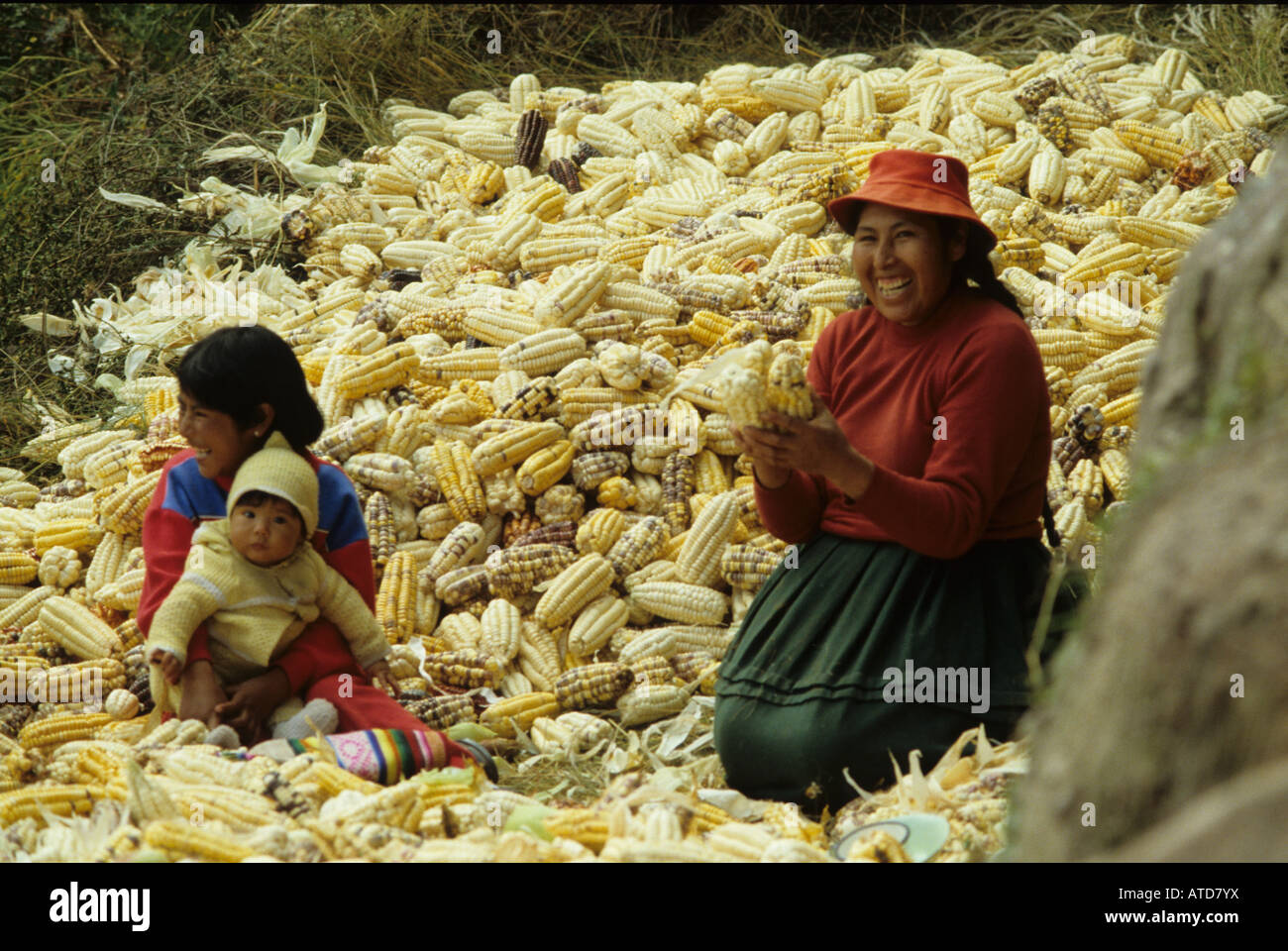 Mother and children happily presenting their colorful corn harvest ...