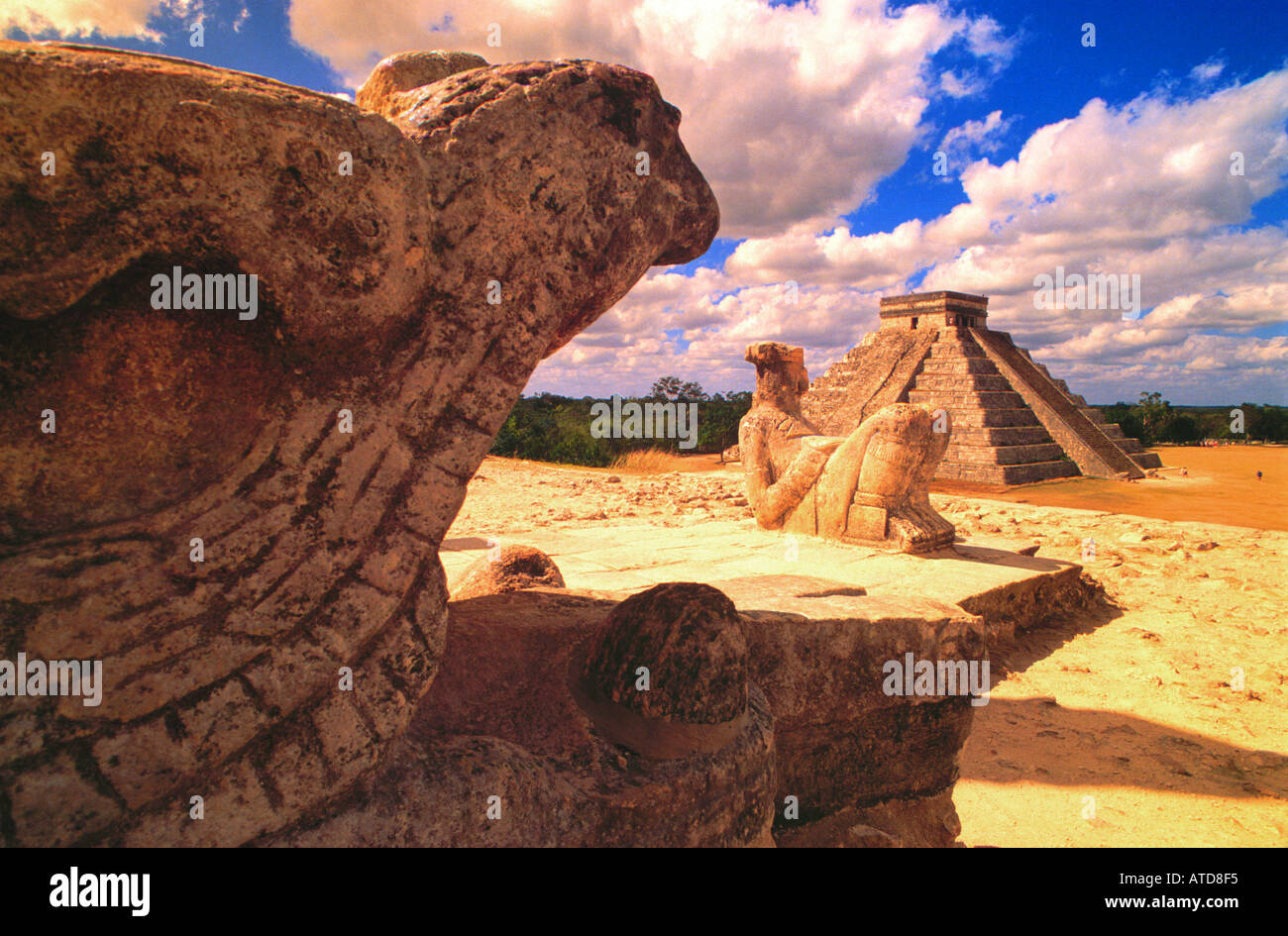 Statues of gods and reptiles sit upon the ruins of Chichen Itza with a ...