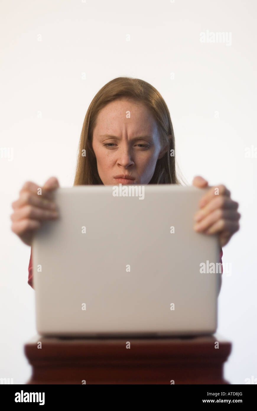 An angry confused young woman looking at her laptop screen Stock Photo ...