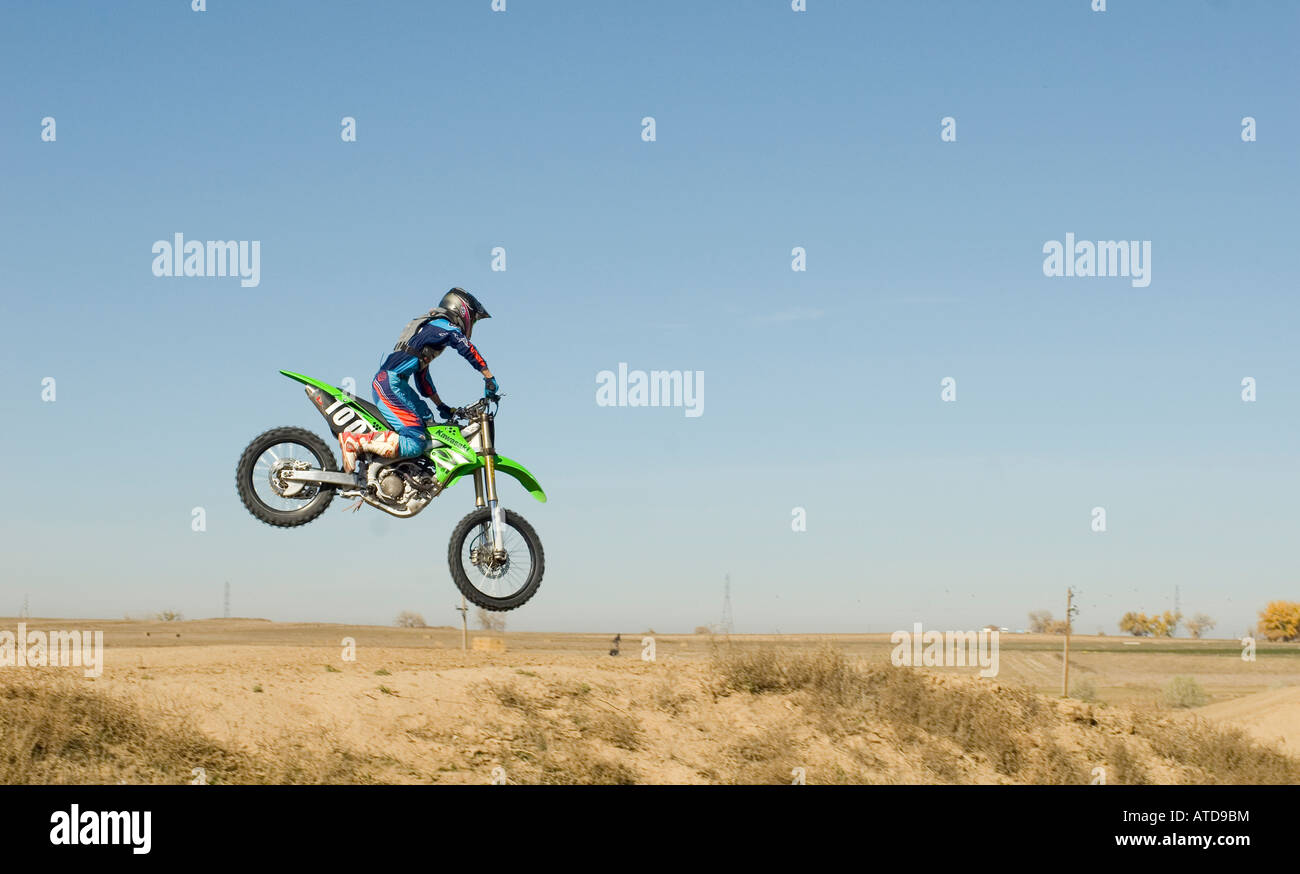Dirt bike motorcycle rider jumping doing a trick at motocross track ...