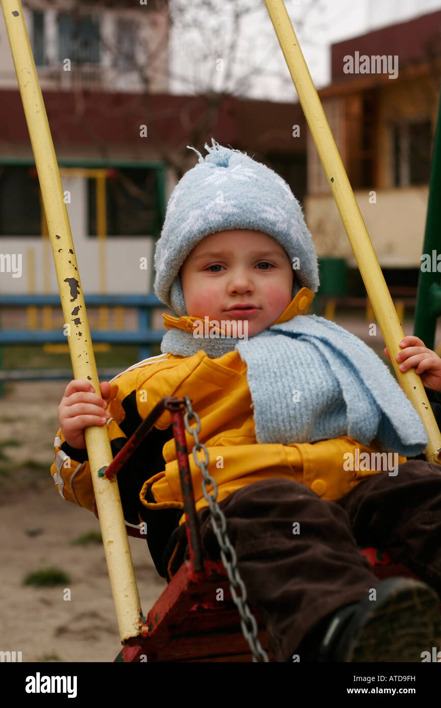 Young child swinging , Boy at a swing at the playground Stock Photo - Alamy