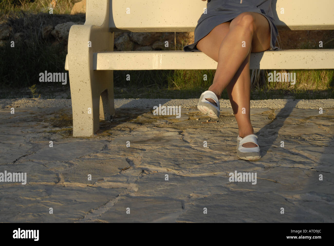 Legs of a tanned brunette young woman sitting relaxed, with legs ...