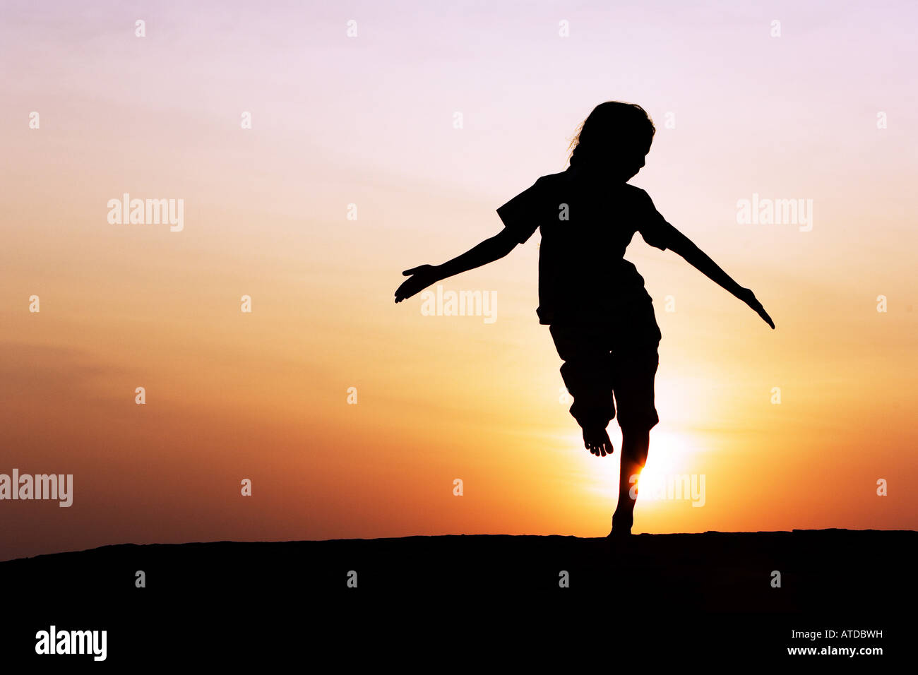 Indian girl silhouette dancing on a rock at sunset. India Stock Photo ...