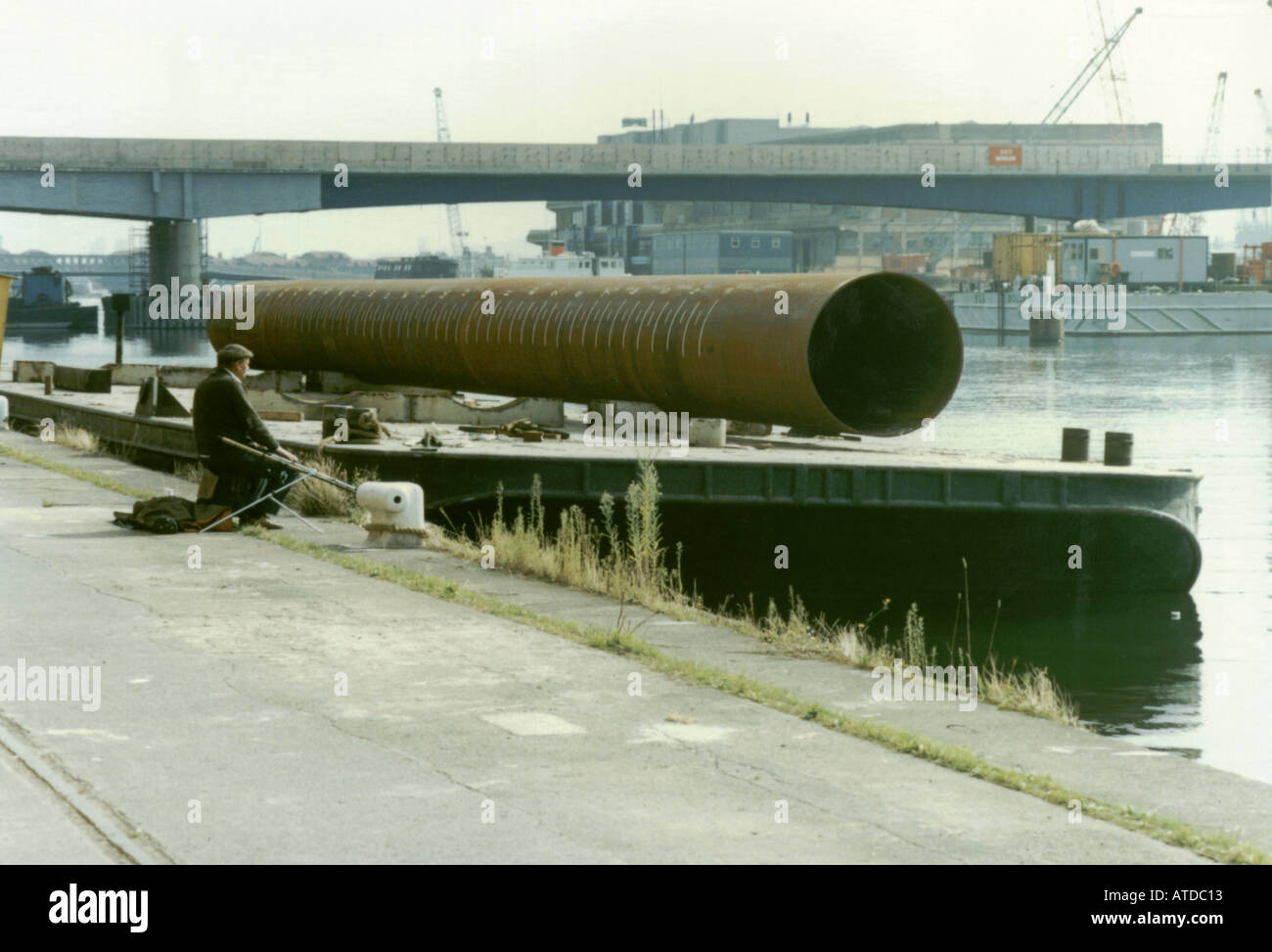 Old and new Dockside fishing next to a piling pipe for Canary Wharf ...