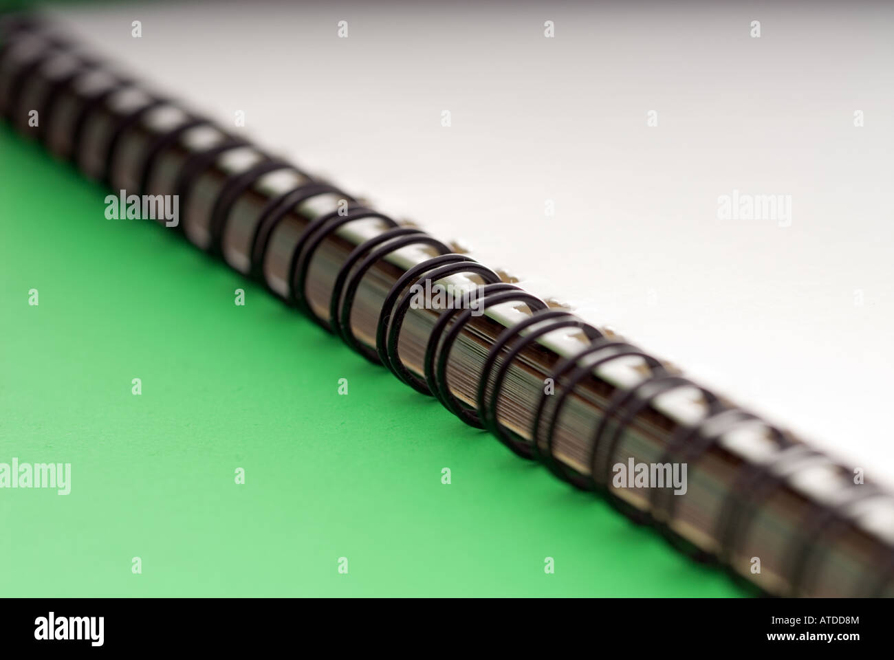macro of a white spiral ring bound document on a green background Stock ...