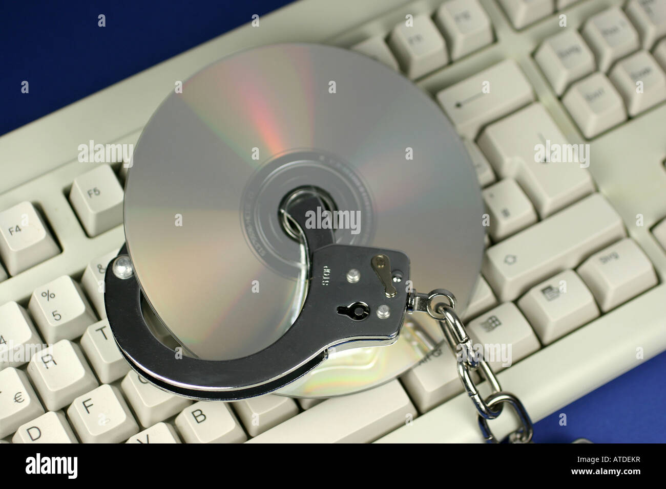 Computer keyboard with CD and handcuffs Stock Photo - Alamy