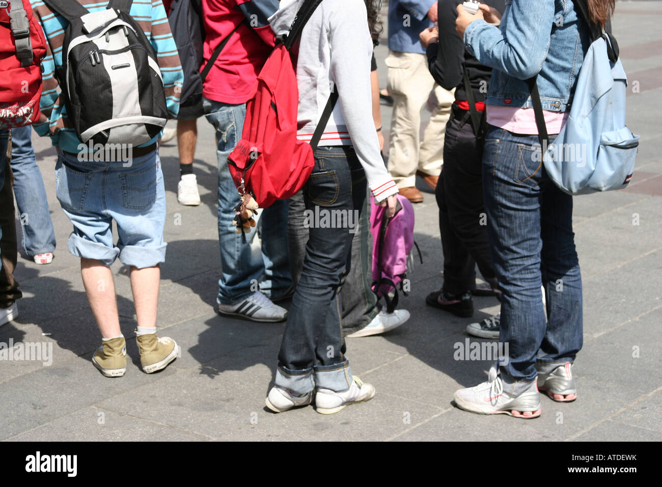 group of young people standing waiting at a square Stock Photo - Alamy
