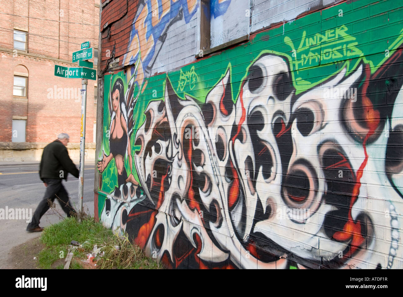 A man walks by graffiti in the Georgetown neighborhood of Seattle Stock ...