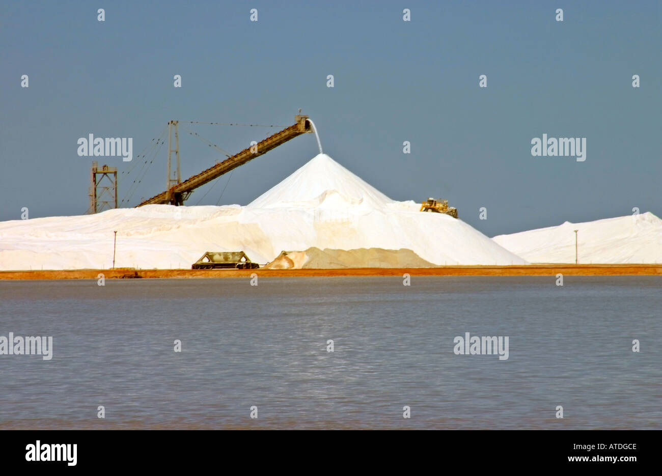 Bulldozer spreading salt around huge pile at salt works near Port ...