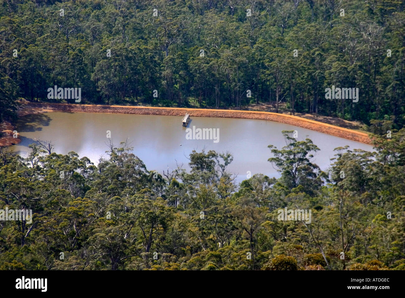 Man made lake with dock surrounded by forest as seen from mountain top ...
