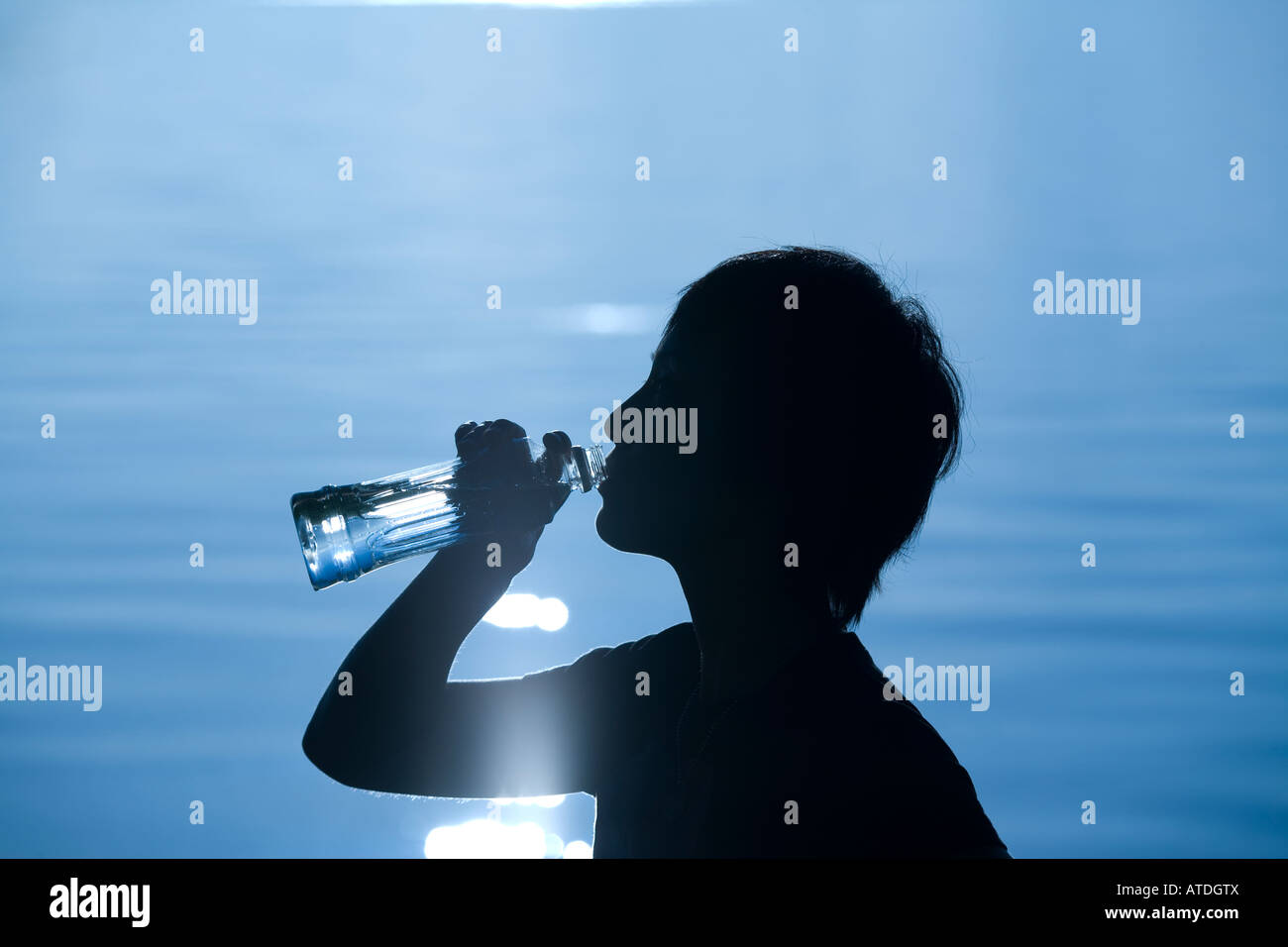 Silhouette of young woman drinking Stock Photo - Alamy