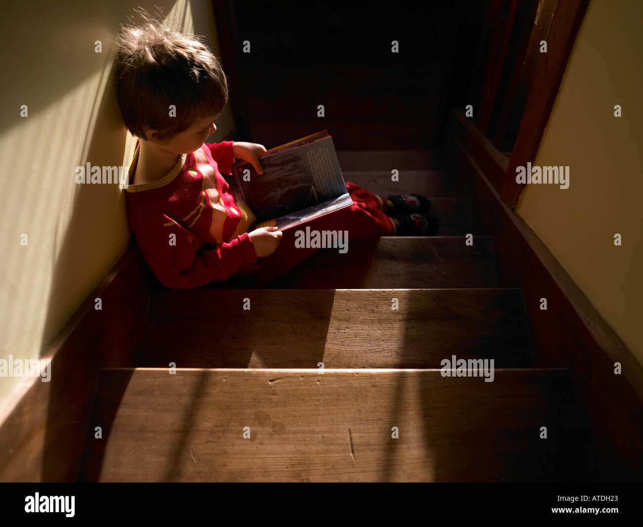 boy reading on stairs Stock Photo - Alamy