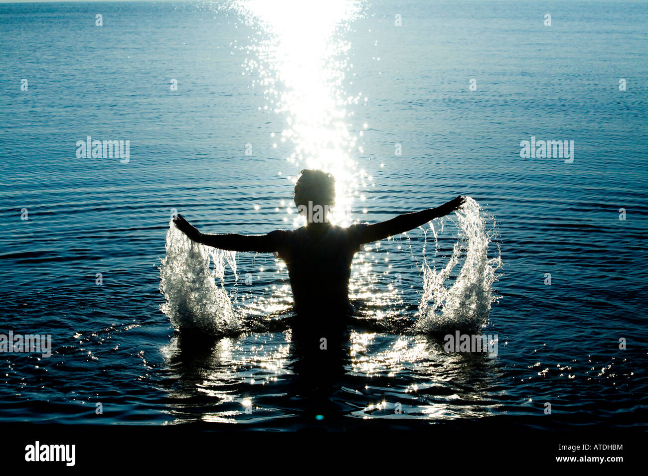Silhouette of young woman wading in lake Stock Photo - Alamy