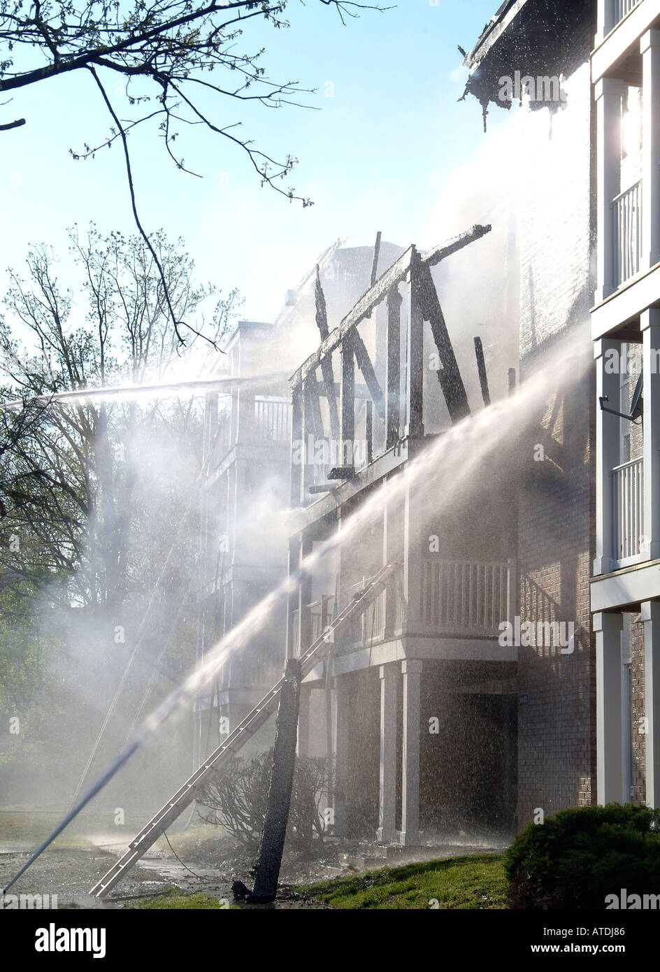 Firefighters pour streams of water into an apt building during a 3 ...