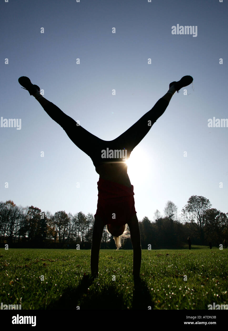 Silhouette of a young woman cartwheeling in the park Stock Photo - Alamy