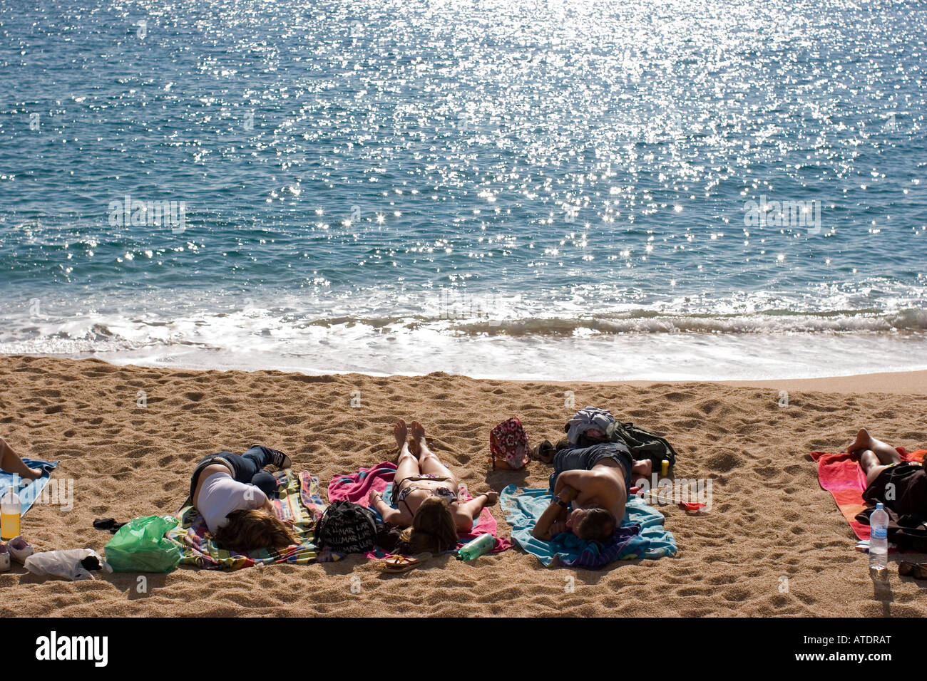 people lying on the sandy beach in the sun Stock Photo - Alamy