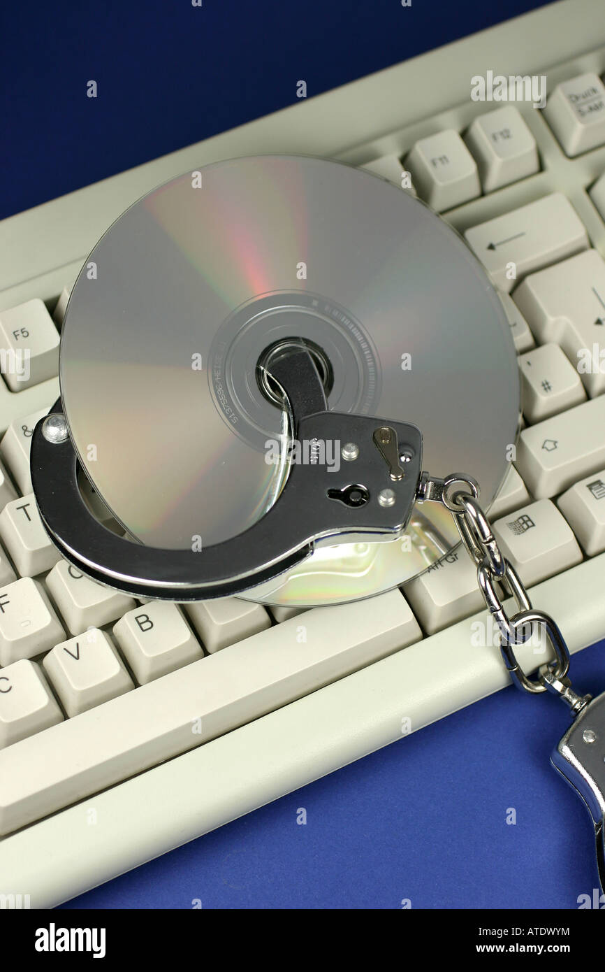 Computer keyboard with CD and handcuffs Stock Photo - Alamy