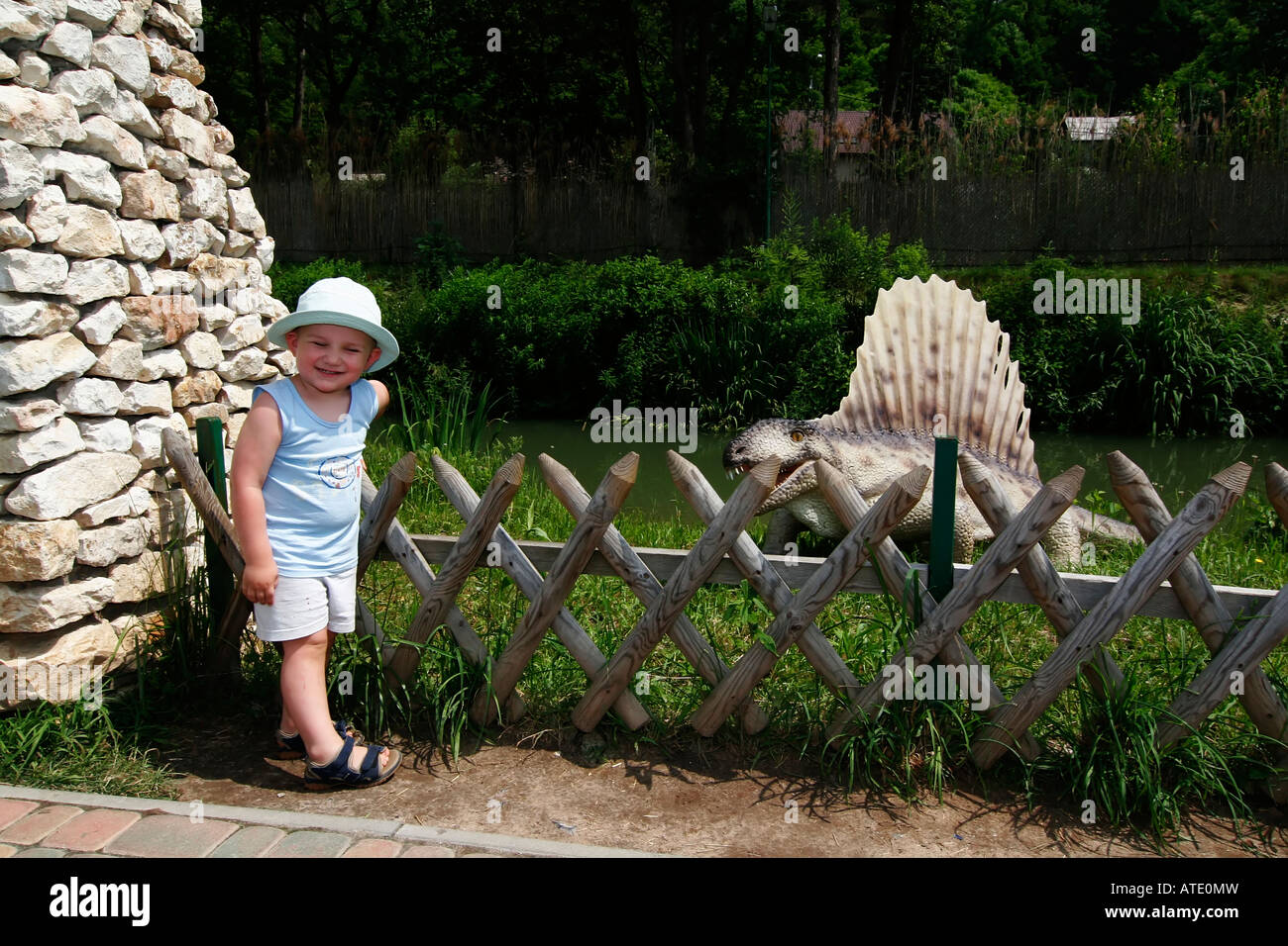 Dinosaur theme park, kid stay close to the fence Stock Photo - Alamy