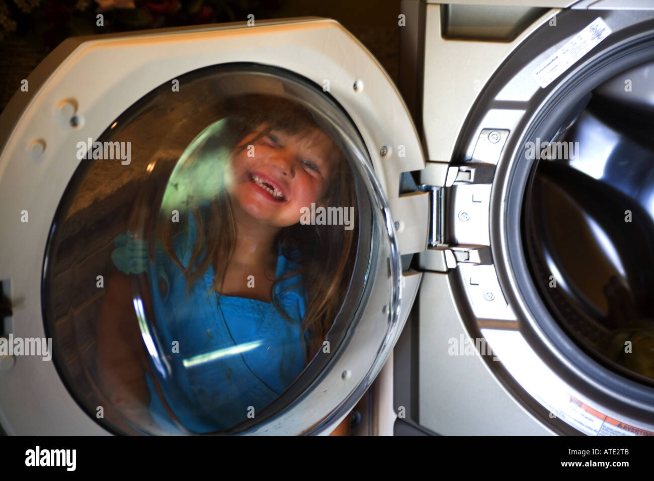 Little girl seen through open door of washing machine Stock Photo - Alamy