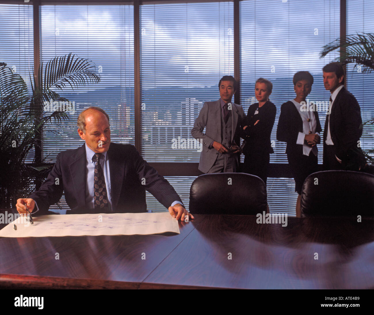 senior architect reviewing plans as employees watch Stock Photo - Alamy
