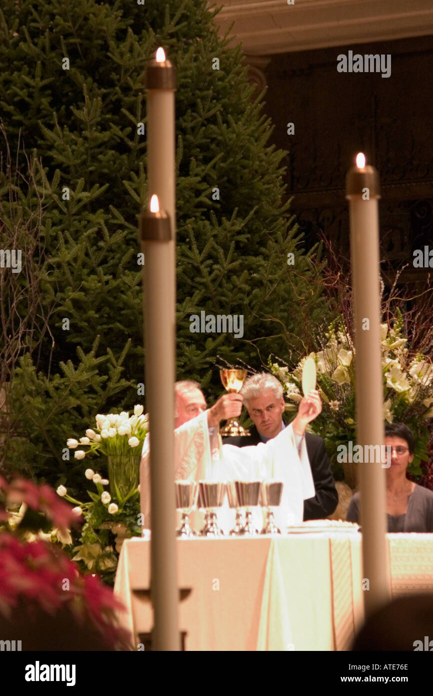 Priest holding up bread and wine chalice during Christmas Pageant at ...