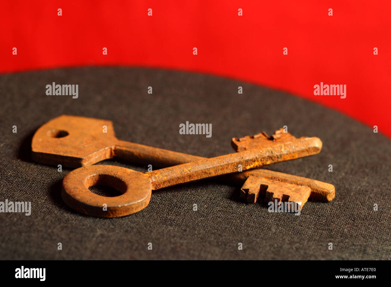 Two old golden keys with a red background Stock Photo - Alamy