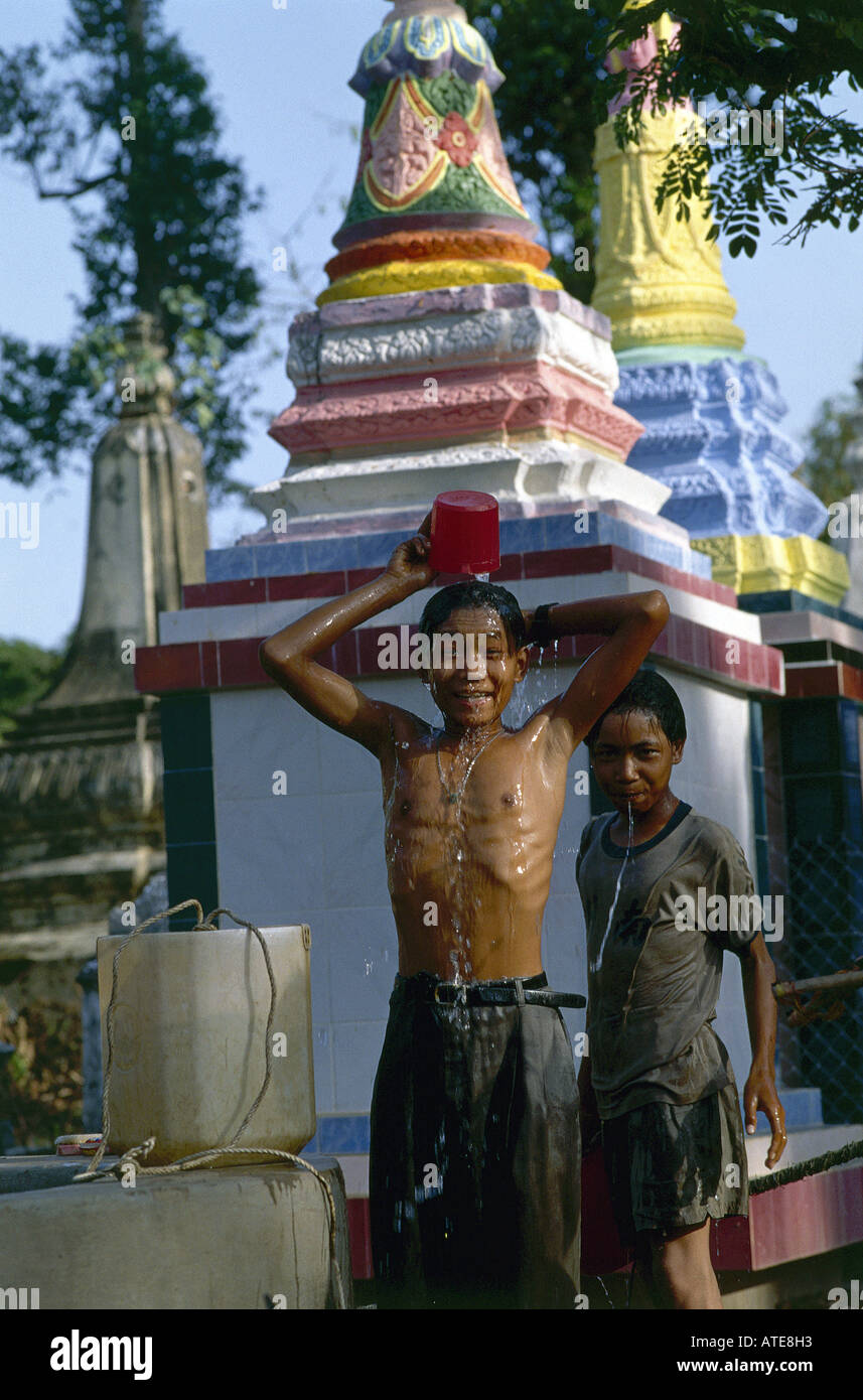 Children indulge in a spiritual shower in front of the burial stupas at ...