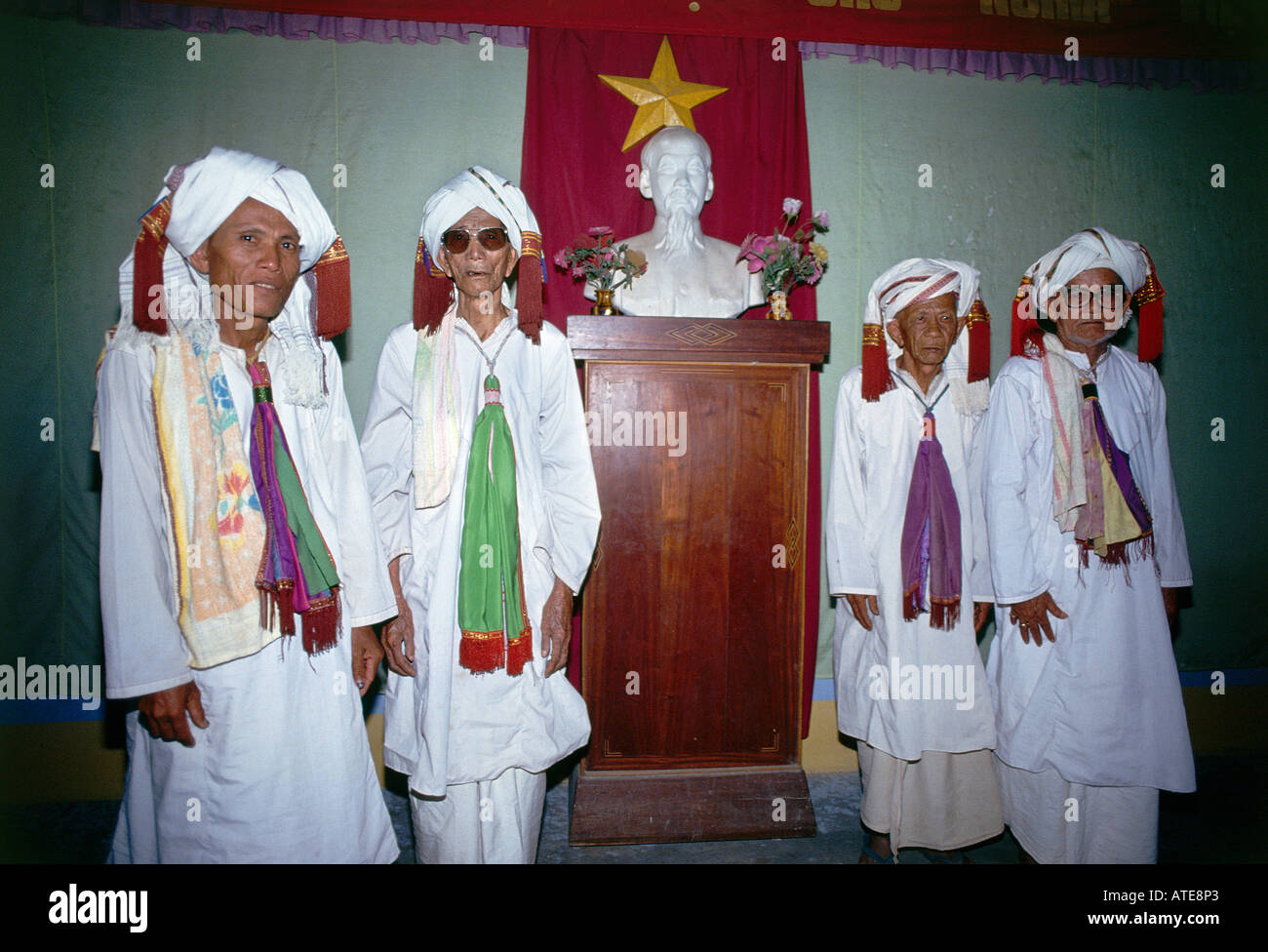 Muslim Cham village elders in traditional dress pose by a portrait of ...