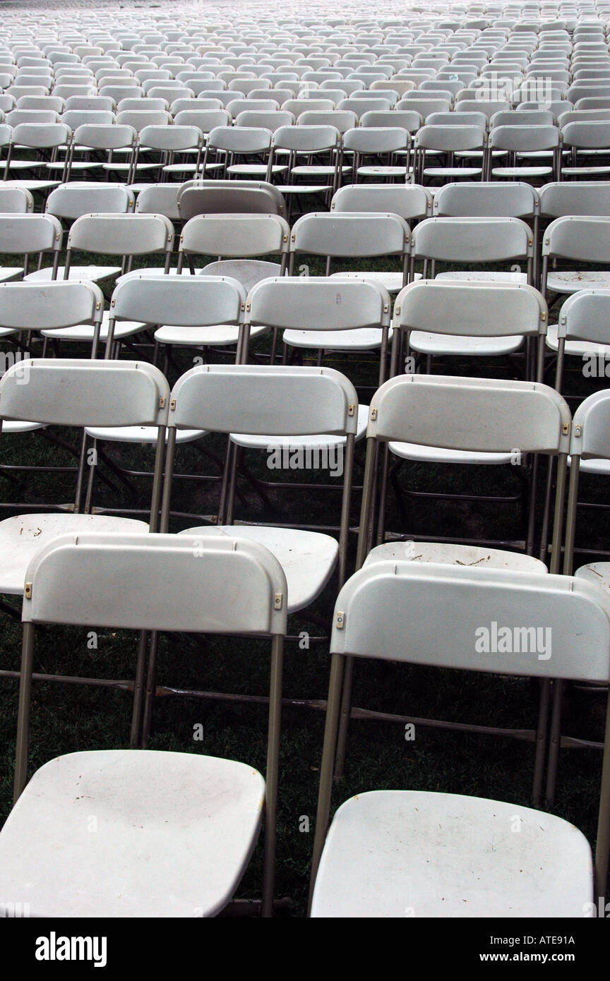 Man taking pictures in Rows of chairs empty at a college graduation ...