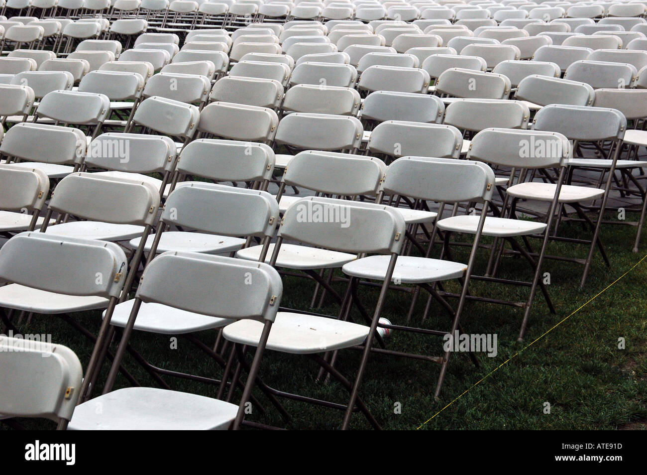 Man taking pictures in Rows of chairs empty at a college graduation ...