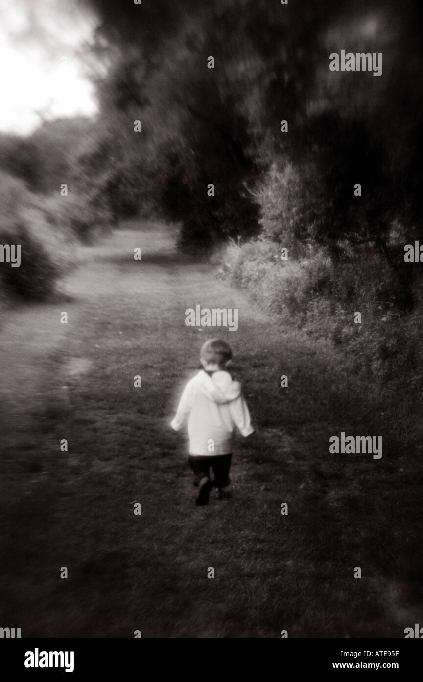 Small child walking on pathway leading away Stock Photo - Alamy