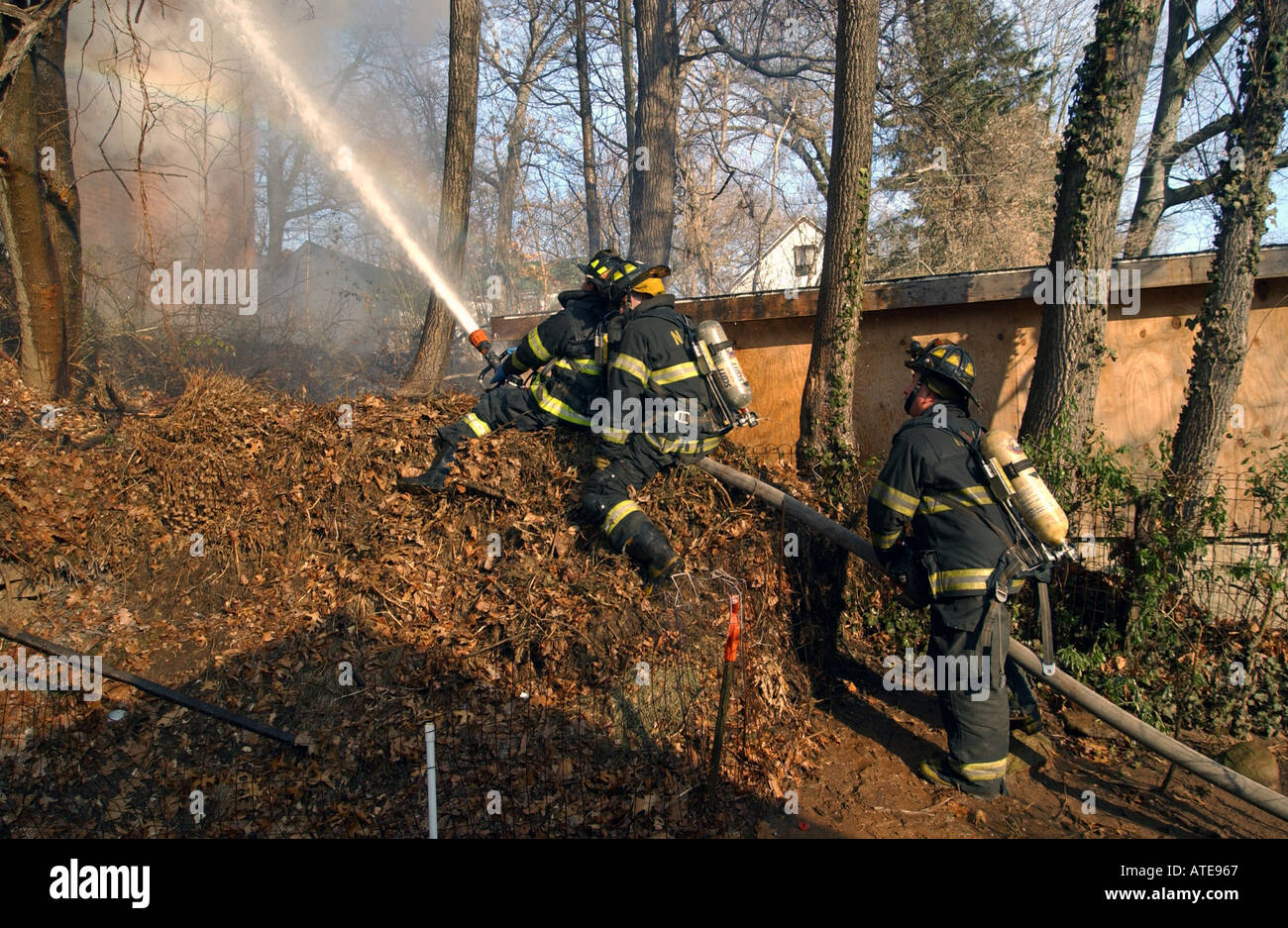 Firefighters spraying hose fighting urban fire Stock Photo - Alamy