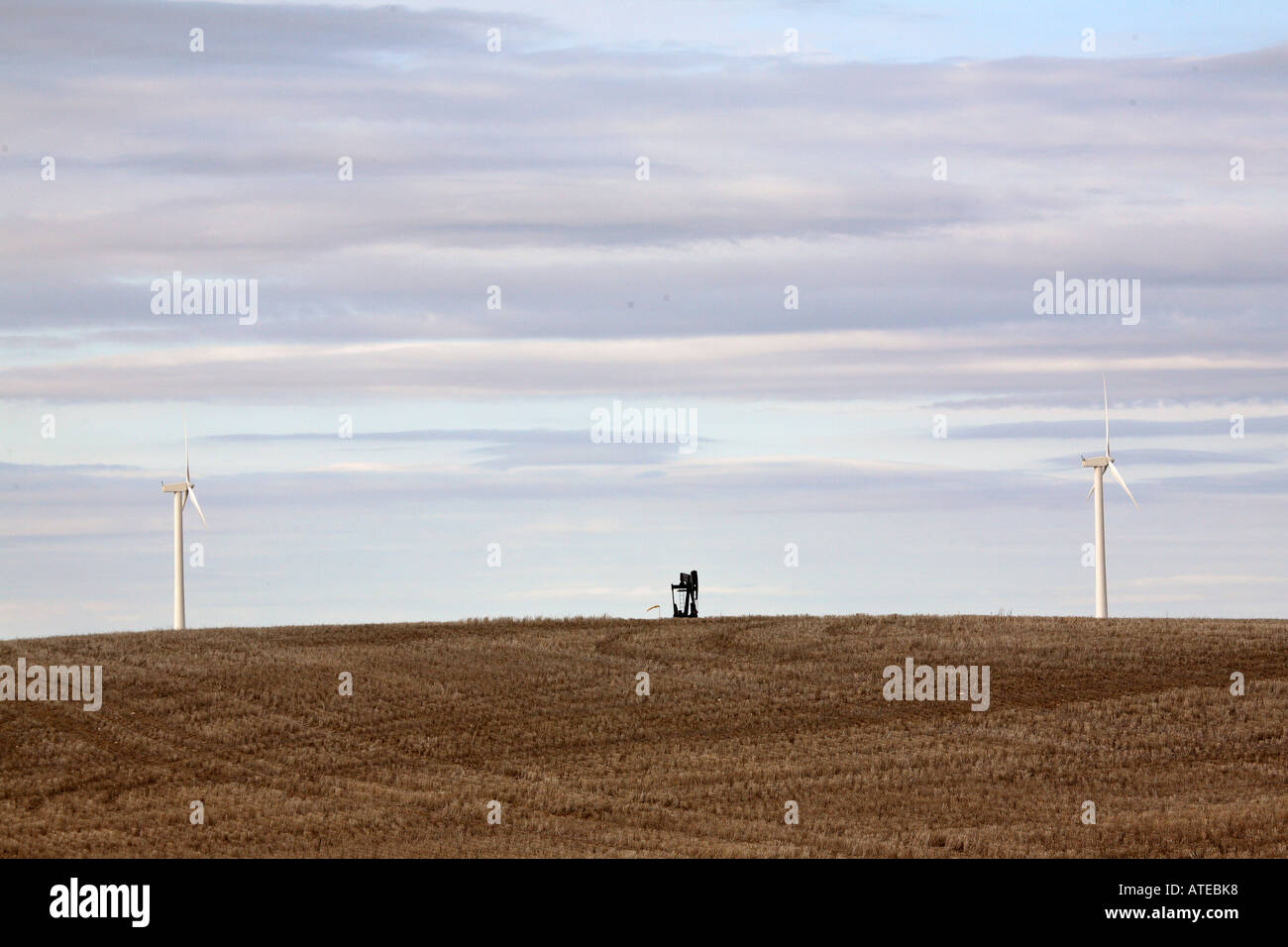 Oil pump between two windmill electricity generators Stock Photo - Alamy