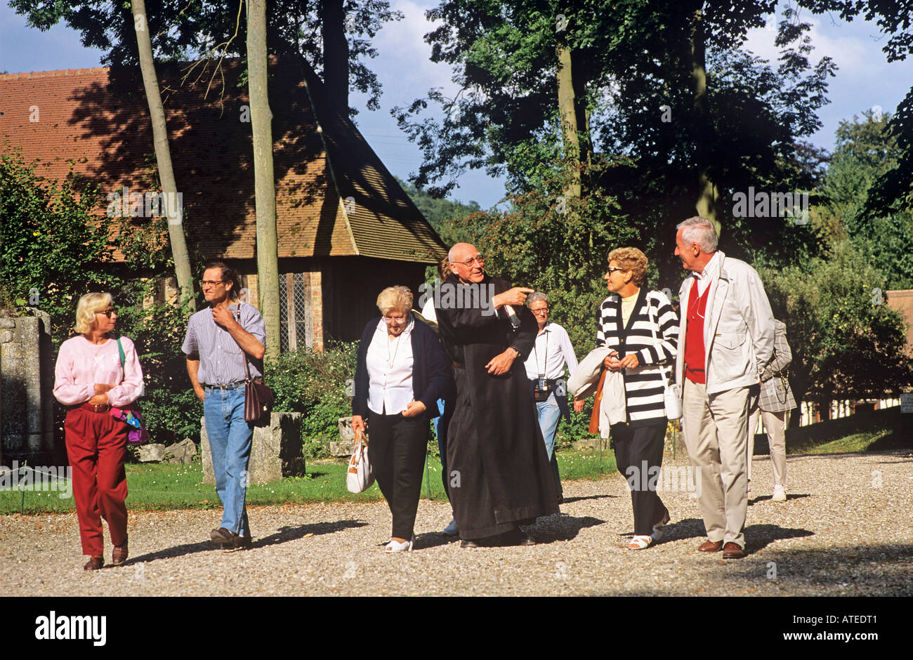 A monk wearing the traditional habit takes a group of visitors on a ...