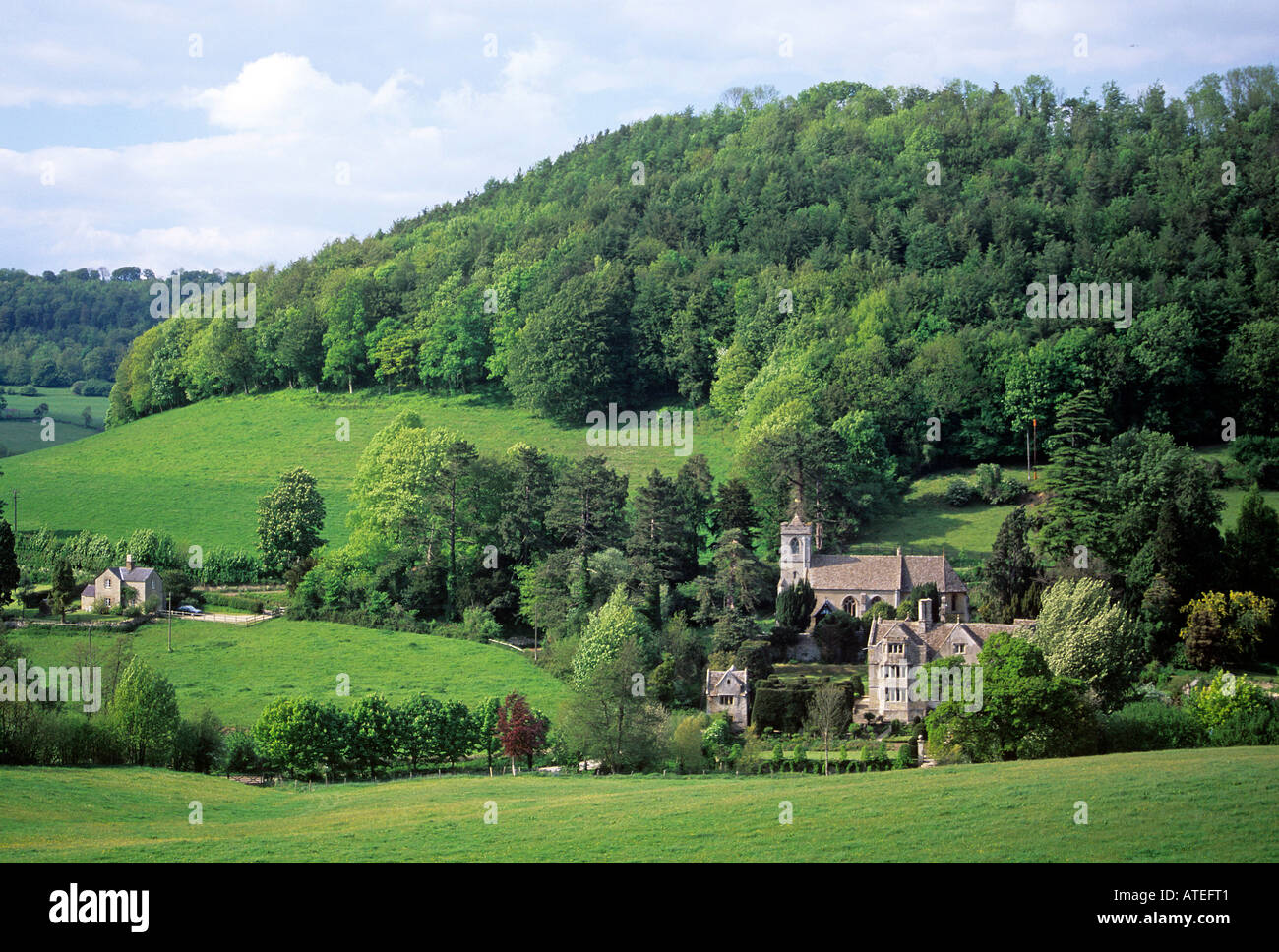 A church nests at the bottom of one of the hills of the Cotswolds at ...