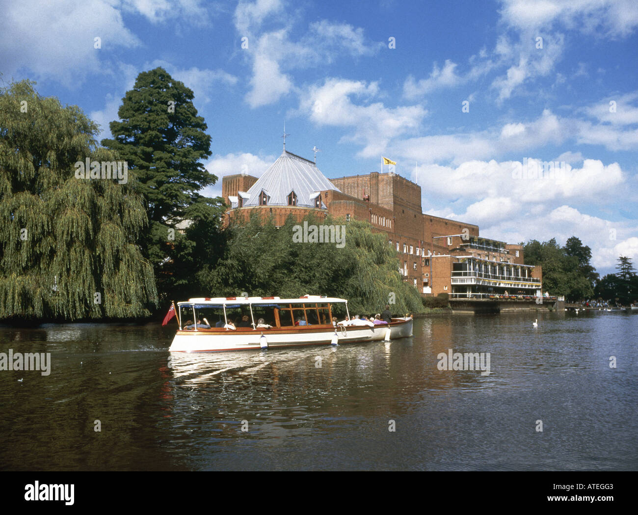 A boat carrying sightseers passes the Shakespeare Memorial Theatre ...