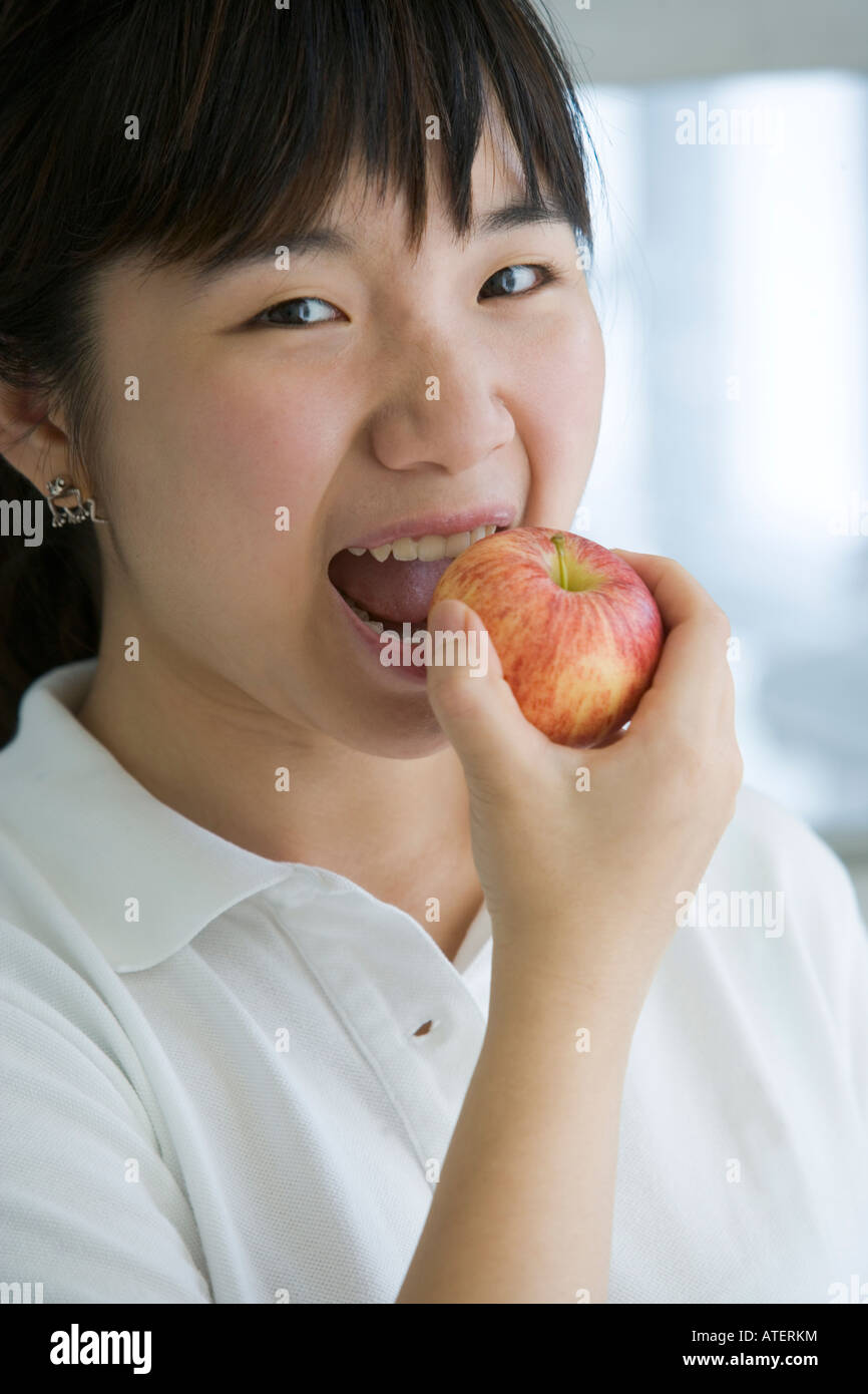 Portrait of a young woman biting an apple Stock Photo - Alamy