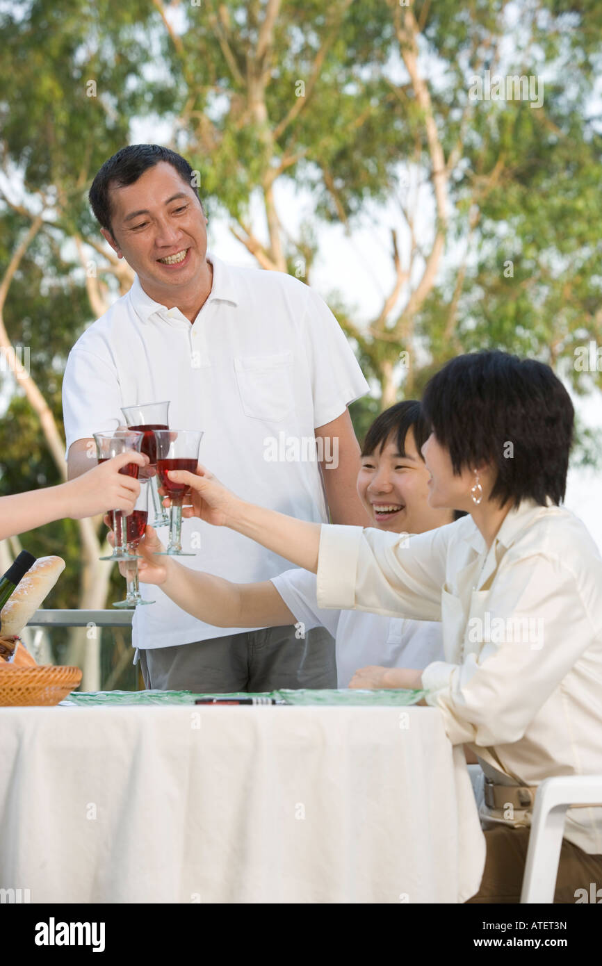 Parents toasting wine with their daughters looking at them Stock Photo ...