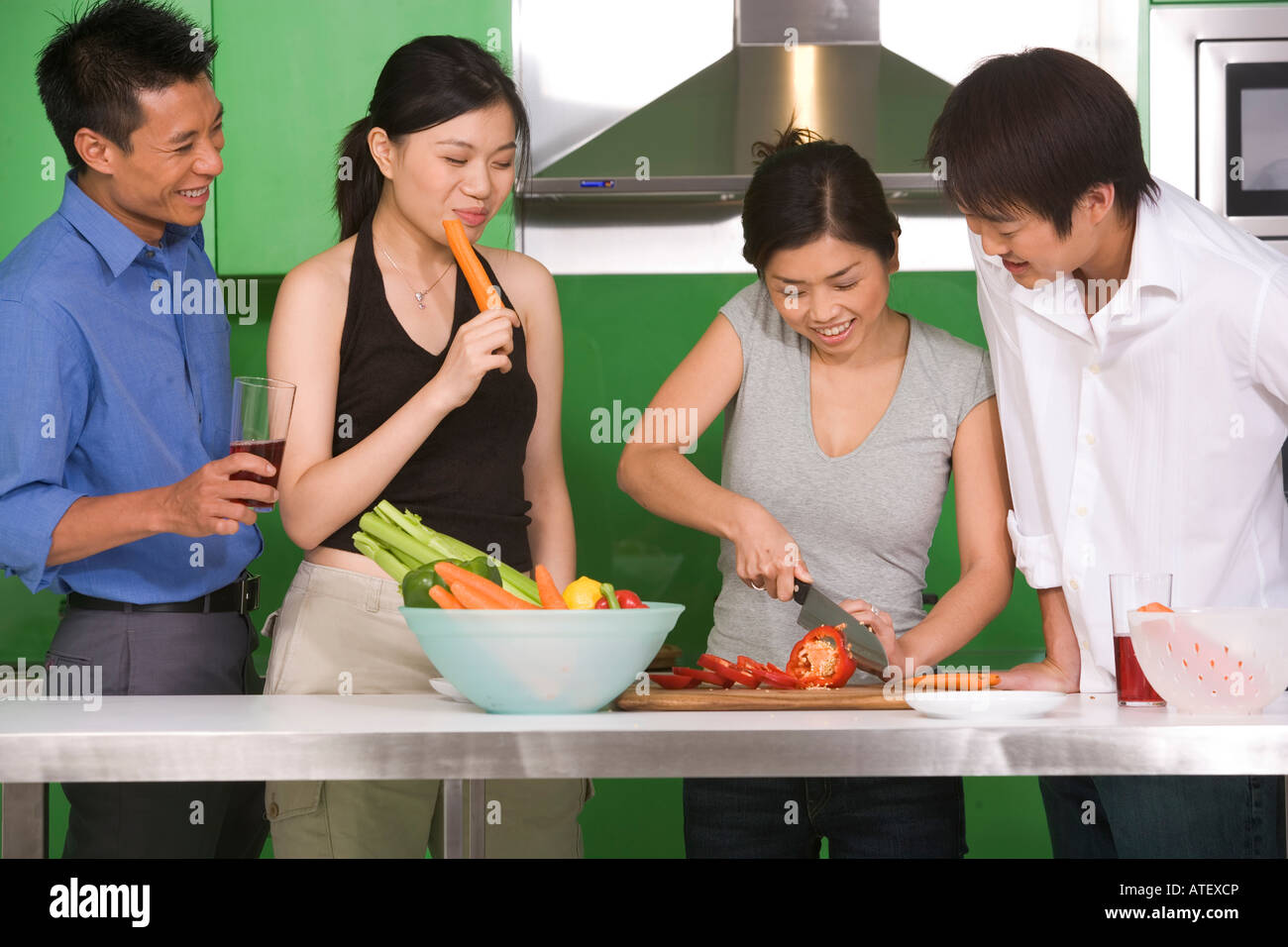 Four friends preparing dinner Stock Photo - Alamy