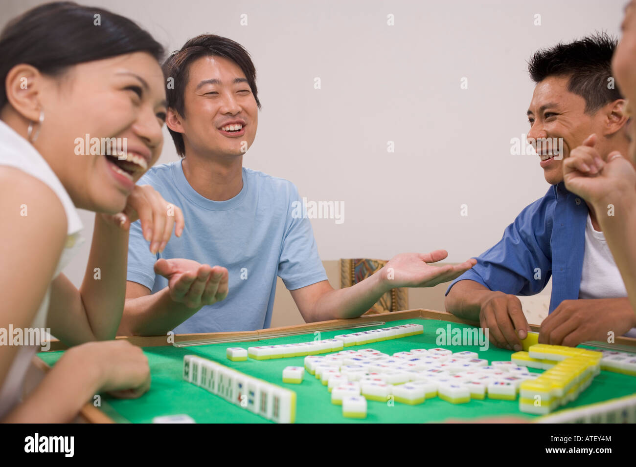 Two young men and two young women playing mahjong Stock Photo - Alamy