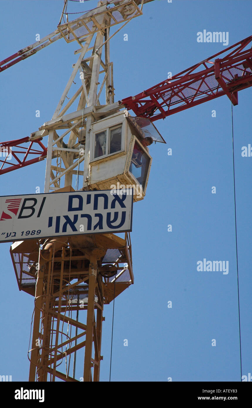 A crane operator looking out of the operation cabin of a large ...