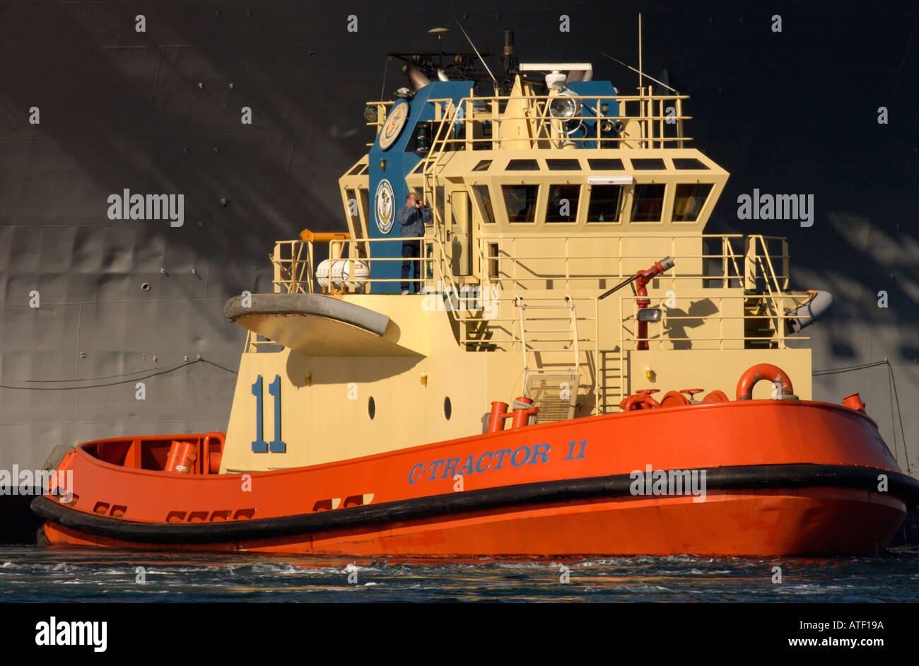 A navy tug pushes the historic aircraft carrier USS Midway to its final ...