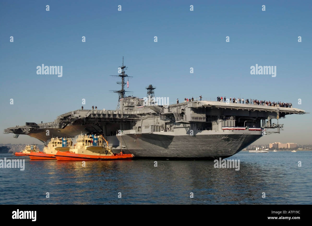 Navy tug boats push the historic aircraft carrier USS Midway to its ...