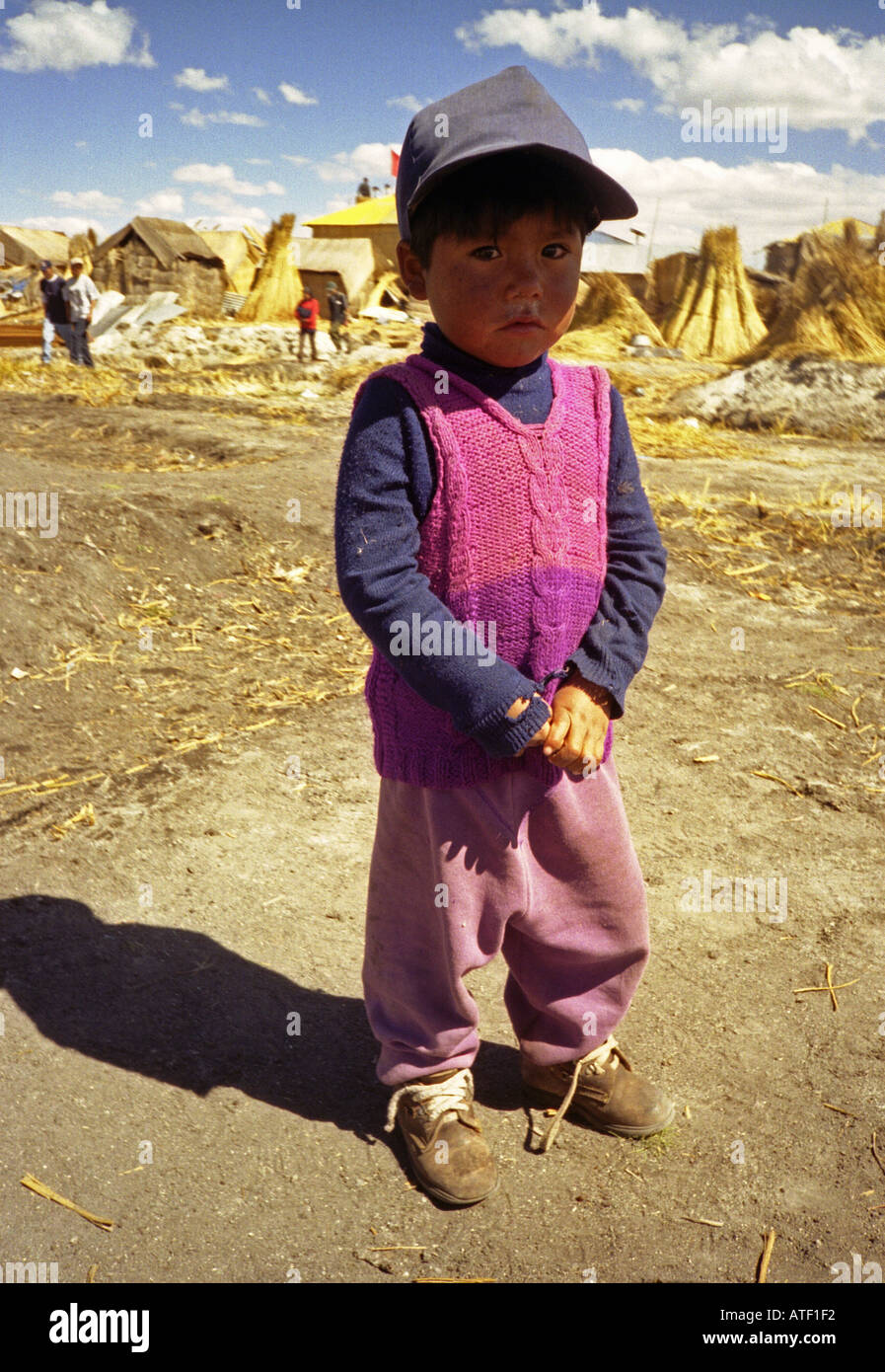 Little shy sad indigenous child boy stand look hold hand outdoor cap ...