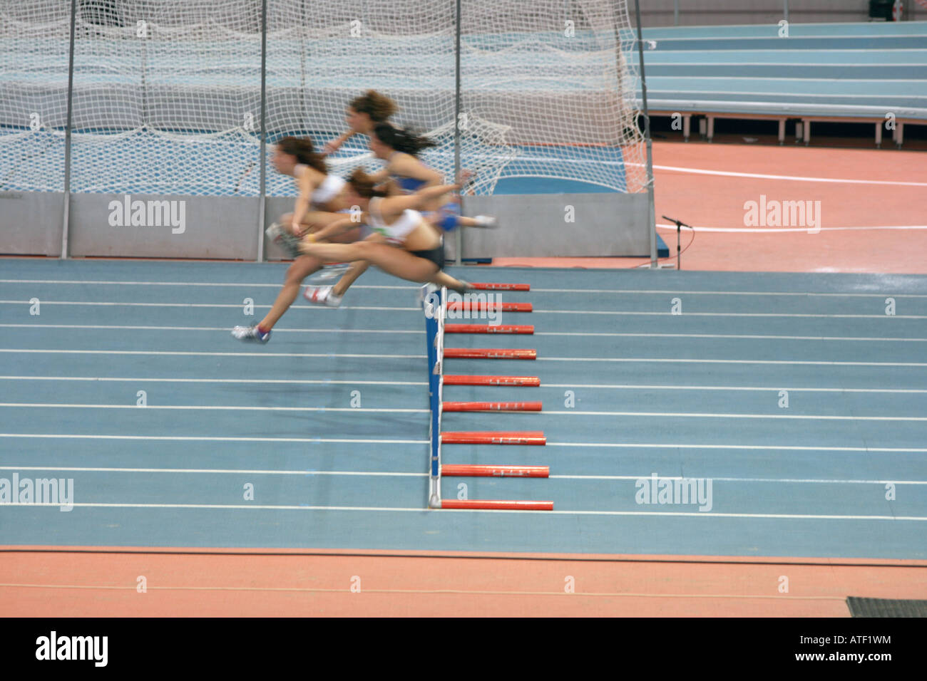 indoors women 60 meters low hurdlers race in action Stock Photo - Alamy