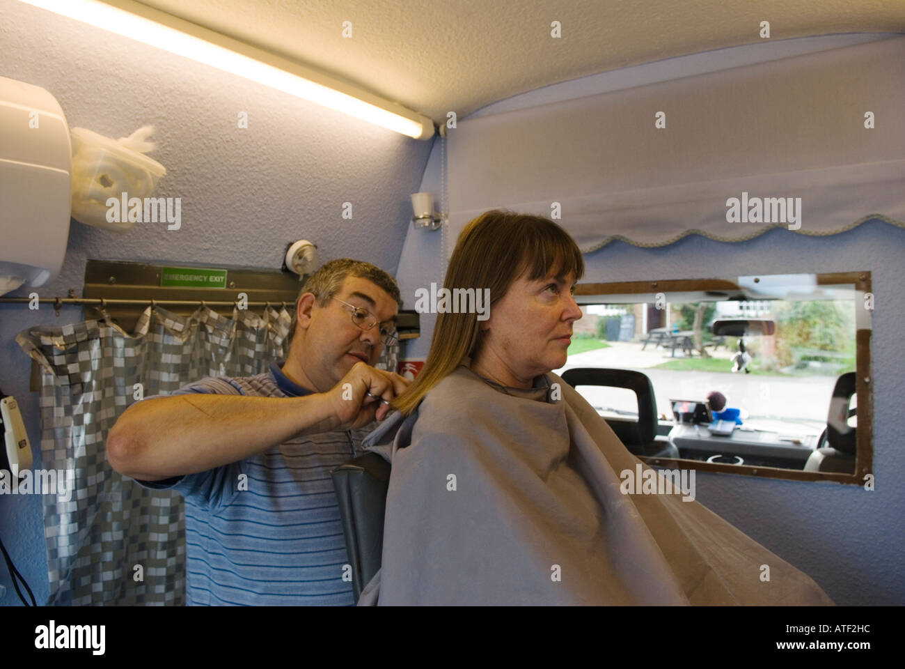 Mobile Barbers interior woman having her hair cut interior of van in ...