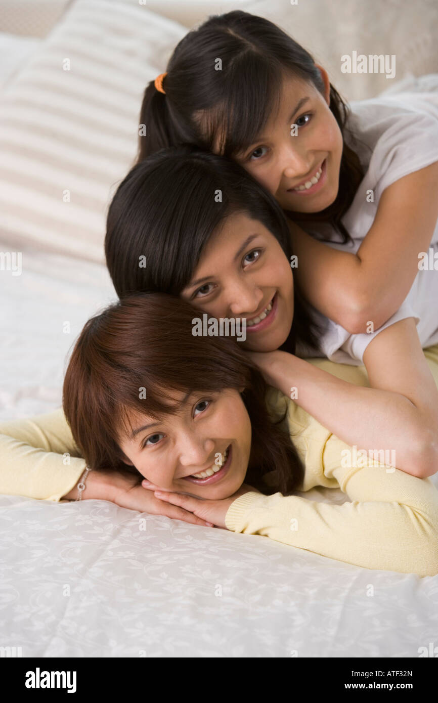 Portrait of three sisters lying on top of each other Stock Photo - Alamy