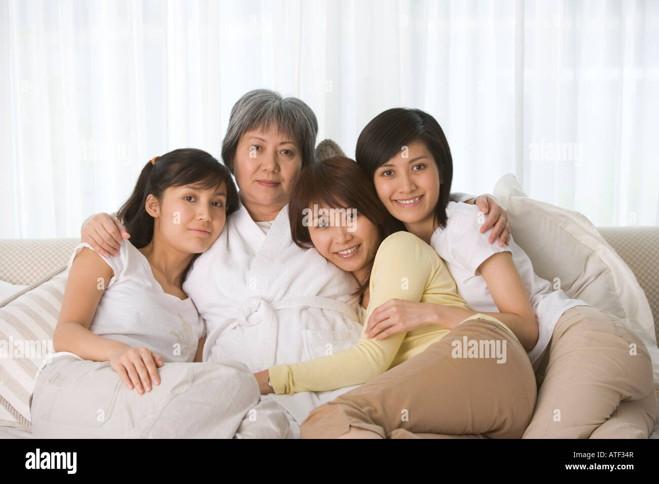 Portrait of a mother with her three daughters smiling Stock Photo - Alamy