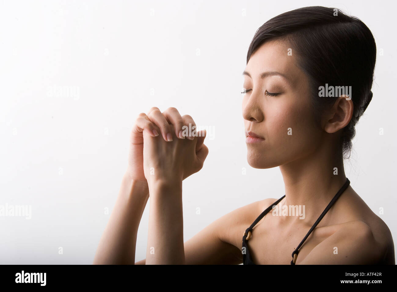 Portrait of young Chinese woman praying Stock Photo - Alamy
